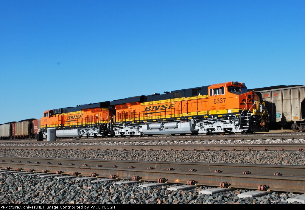 BNSF 6337 and her sister BNSF 6339 glisten in the morning sun as they wait to push the loaded ...